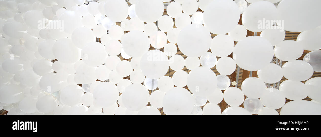 many big white balloons hanging from the ceiling during a ceremony and ...
