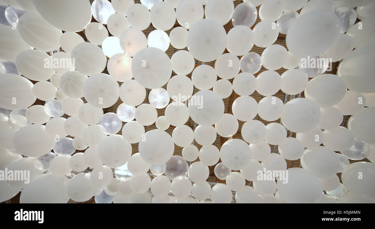 many big white balloons hanging from the ceiling during a ceremony and ...