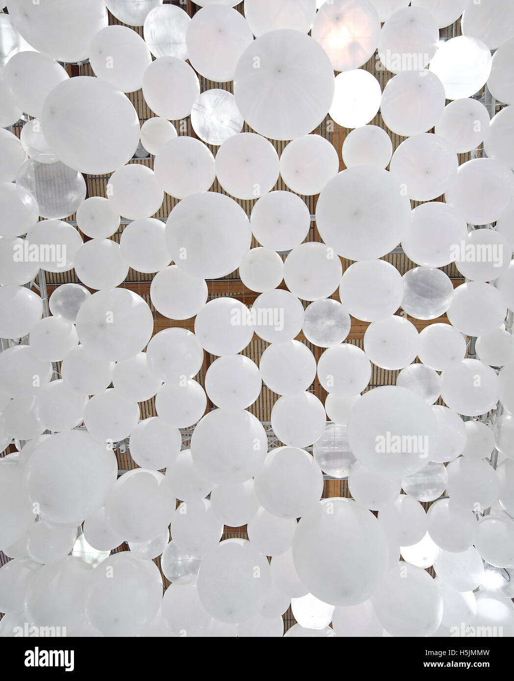 many big white balloons hanging from the ceiling during a ceremony and ...