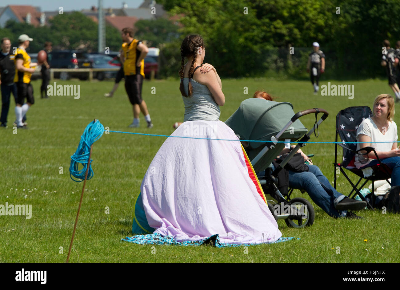 Woman spectator looks like she's wearing a crinoline as she stands by a ...