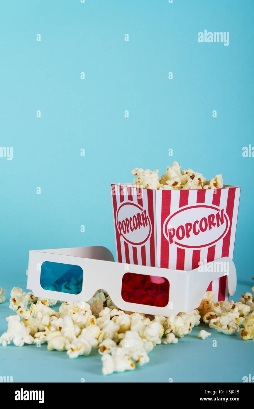 Bucket of popcorn against a blue background Stock Photo - Alamy