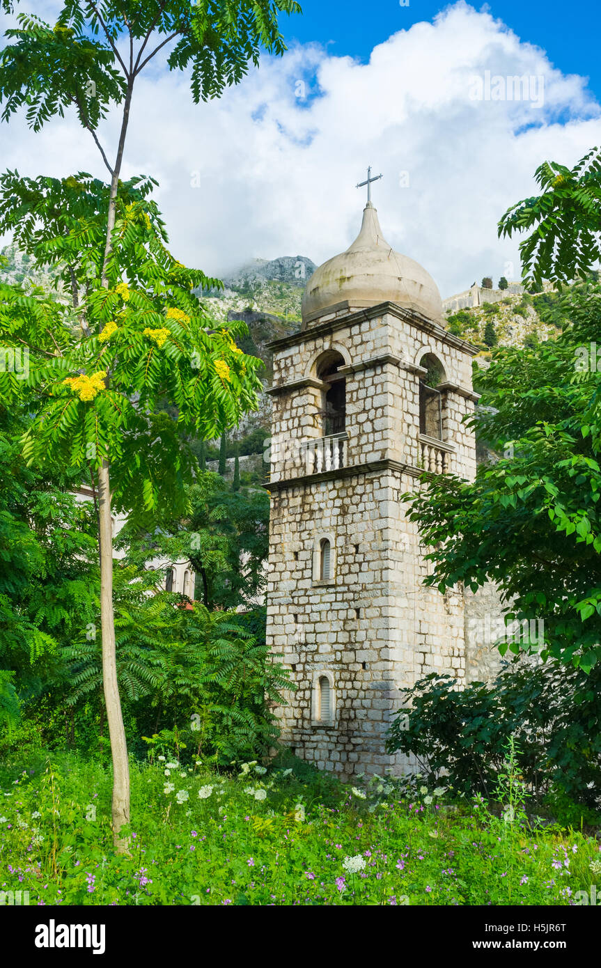 The old belfry is hidden among the green trees and bushes in the scenic ...