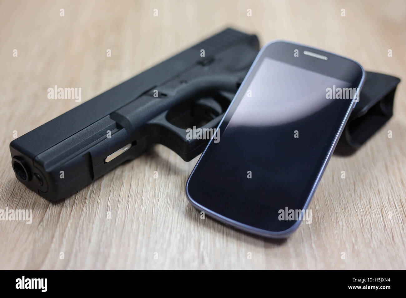 A gun and a modern smart phone Stock Photo - Alamy