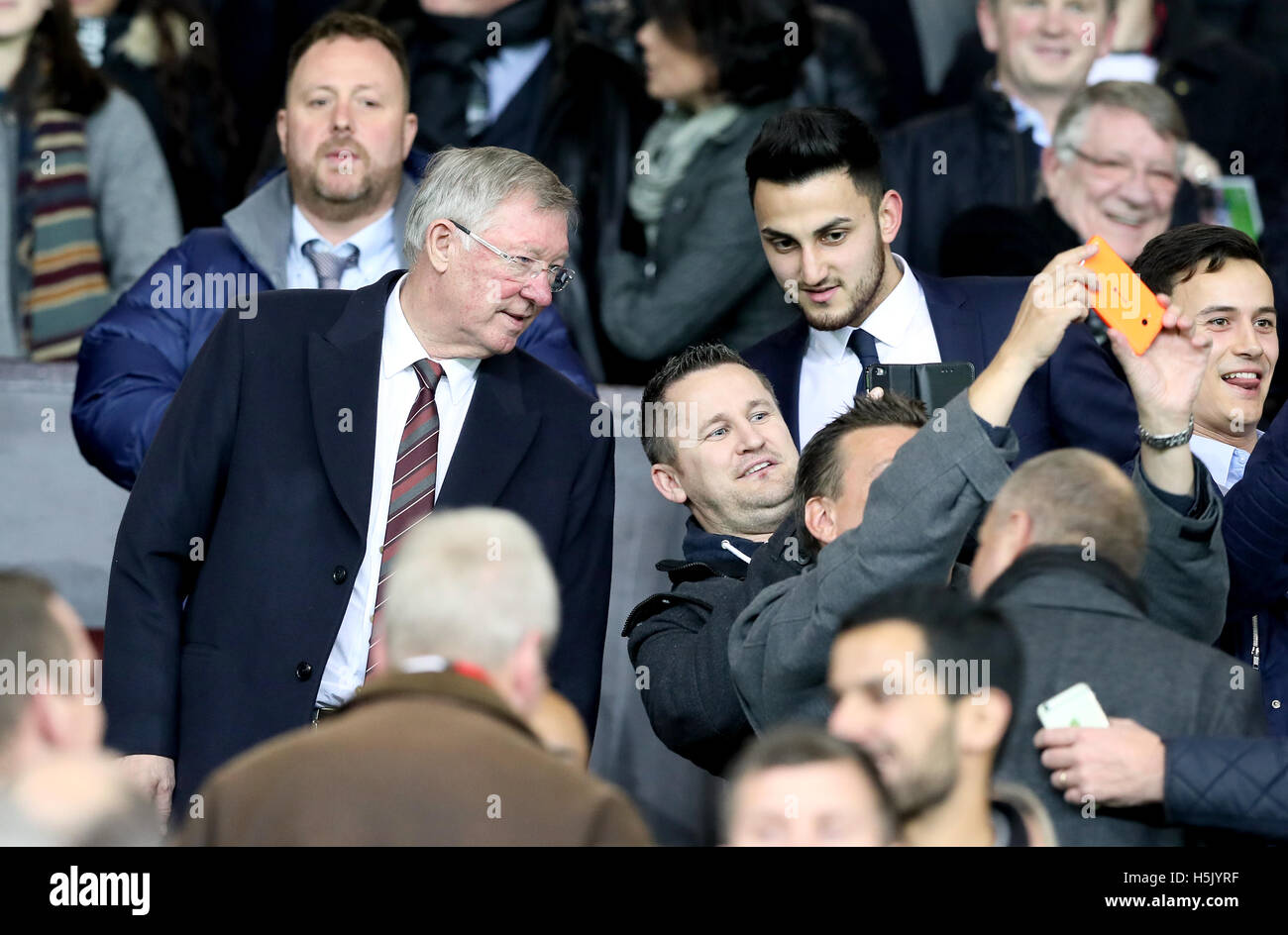 Sir Alex Ferguson poses for a photograph with a fan in the stands Stock ...