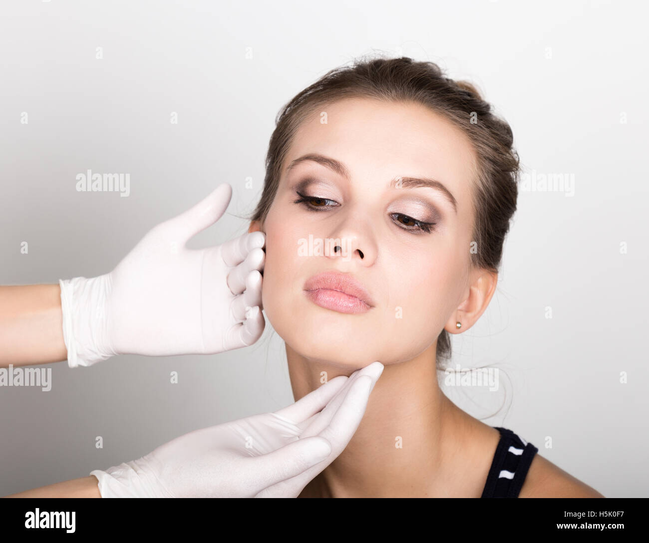 beautician hand's examining beautiful young female face Stock Photo - Alamy
