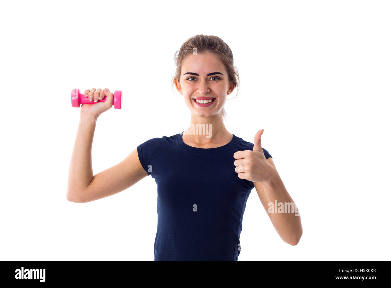 Woman holding a dumbbell and showing thumb up Stock Photo - Alamy