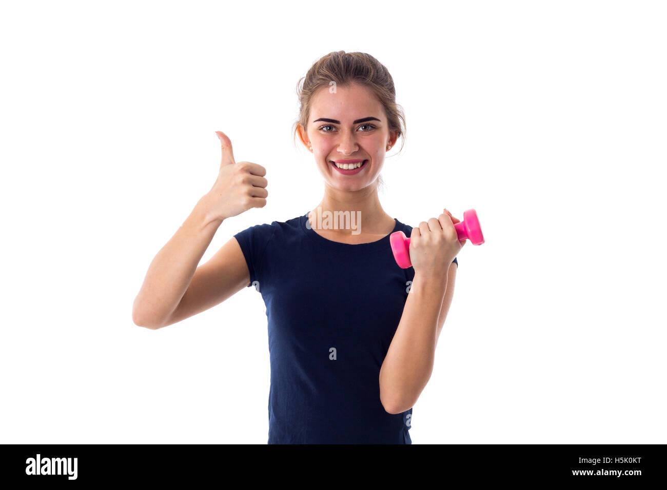 Woman holding a dumbbell and showing thumb up Stock Photo - Alamy