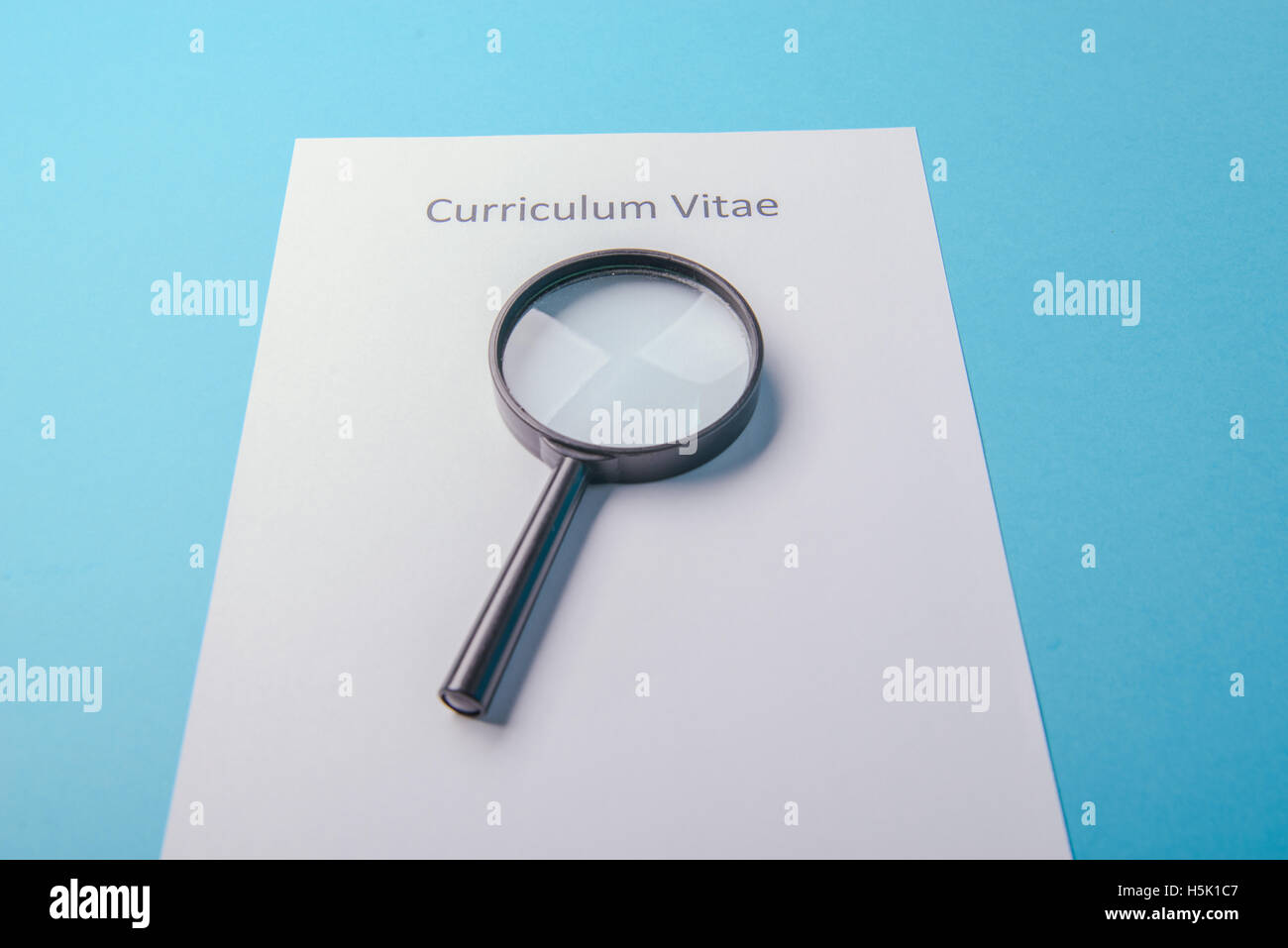 Curriculum vitae written on an blank white paper on blue background ...