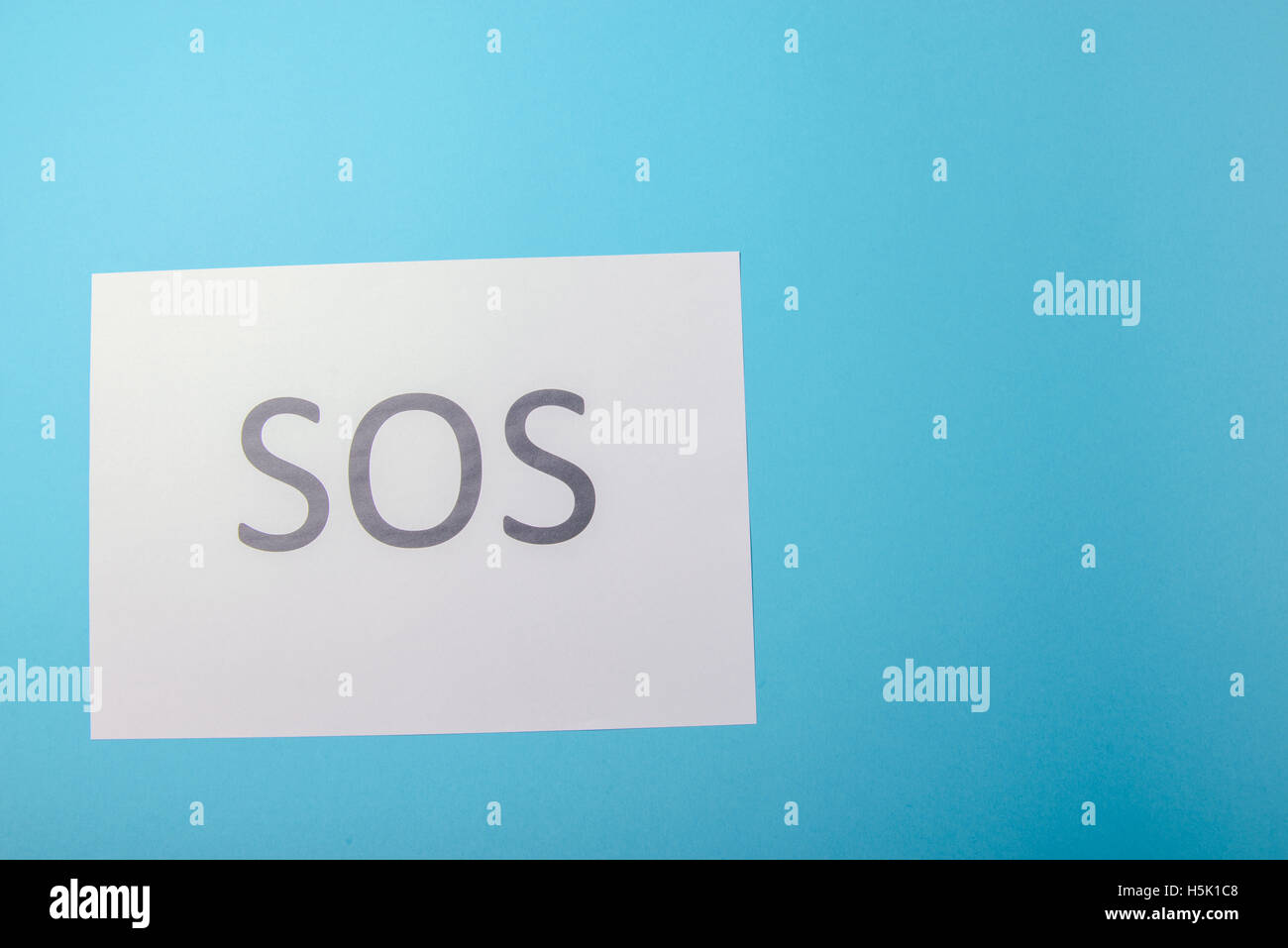 Word SOS written on white paper. Blue background Stock Photo - Alamy