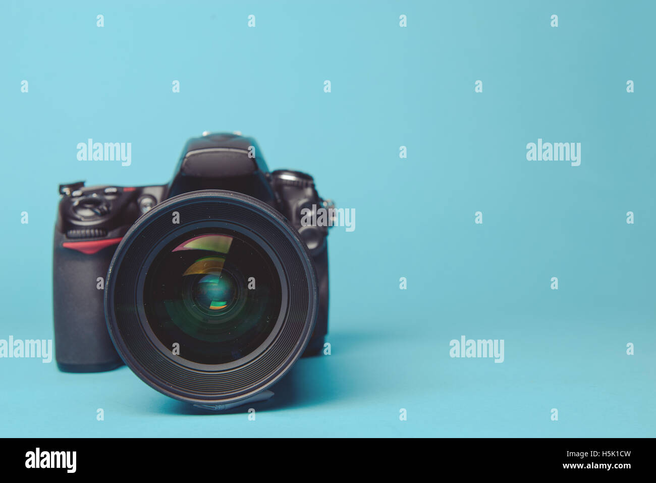 Professional modern DSLR camera against blue background Stock Photo - Alamy