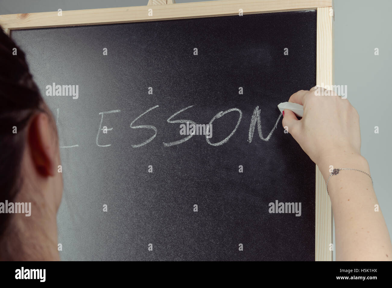 Lesson written in white chalk on a black chalkboard . gray background ...