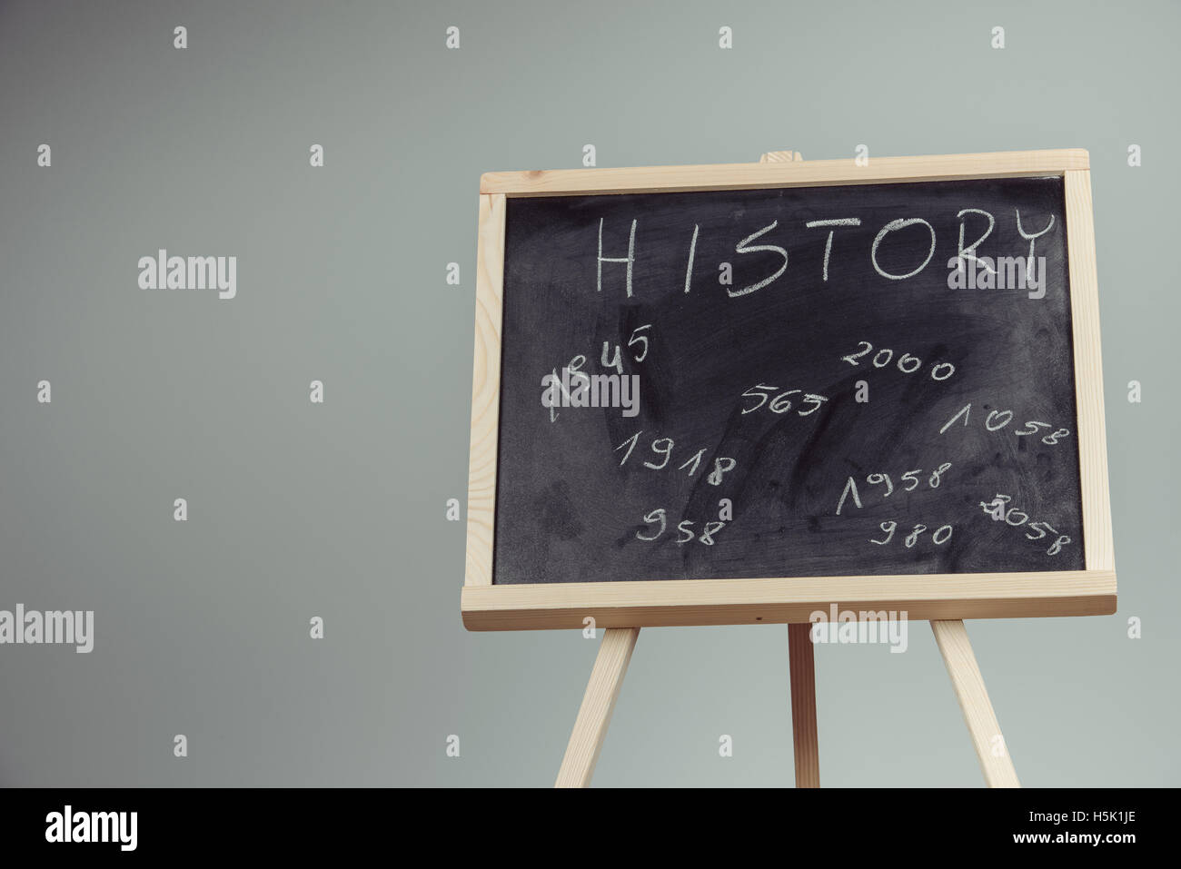 History, written with white chalk on a blackboard. Gray background ...