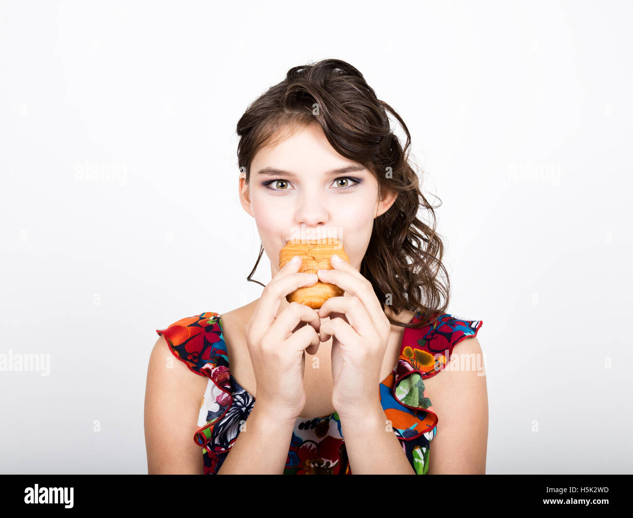 Young smile girl holding and biting bread roll Stock Photo - Alamy