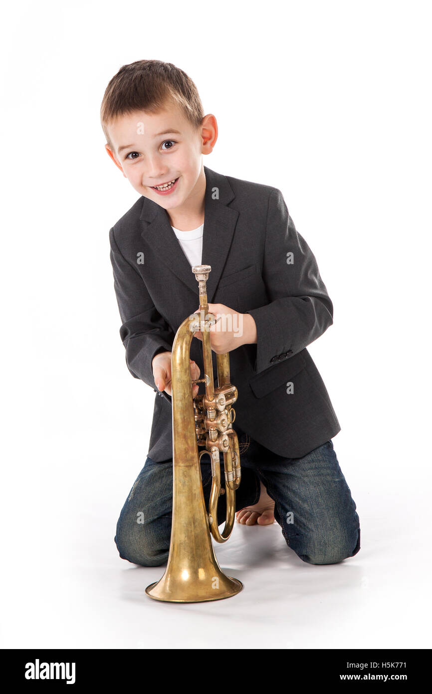 young boy blowing into a trumpet against white background Stock Photo ...