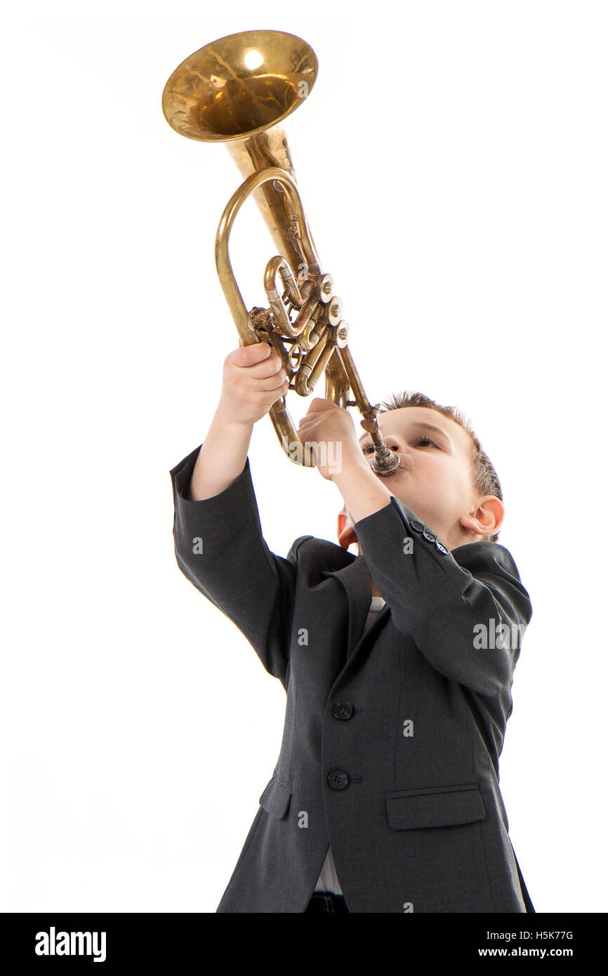 young boy blowing into a trumpet against white background Stock Photo ...