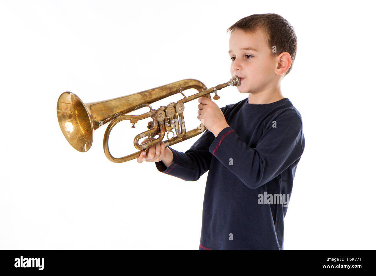 young boy blowing into a trumpet against white background Stock Photo ...