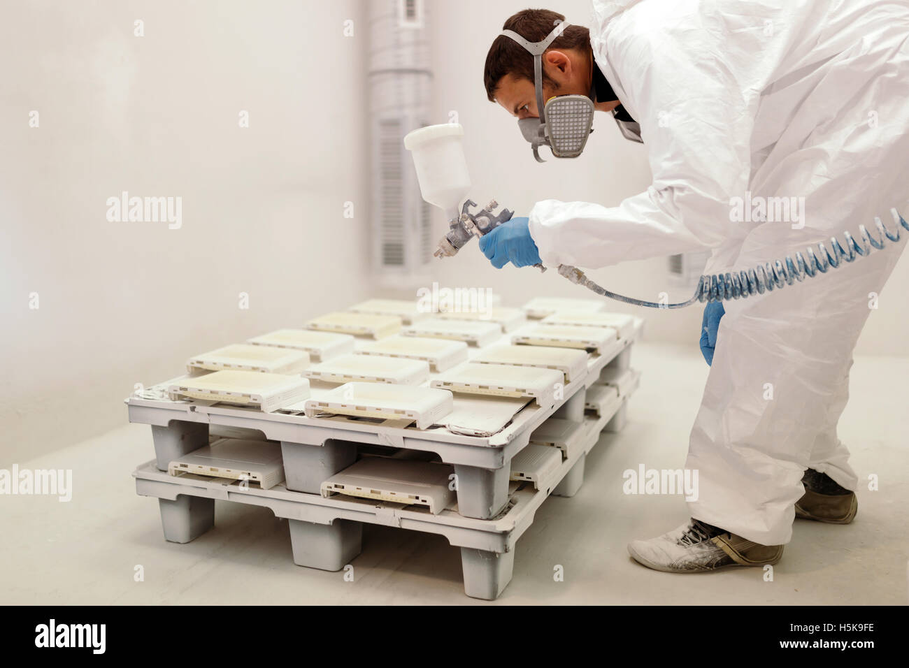 Painter using airbrush to paint wearing protective clothing Stock Photo ...