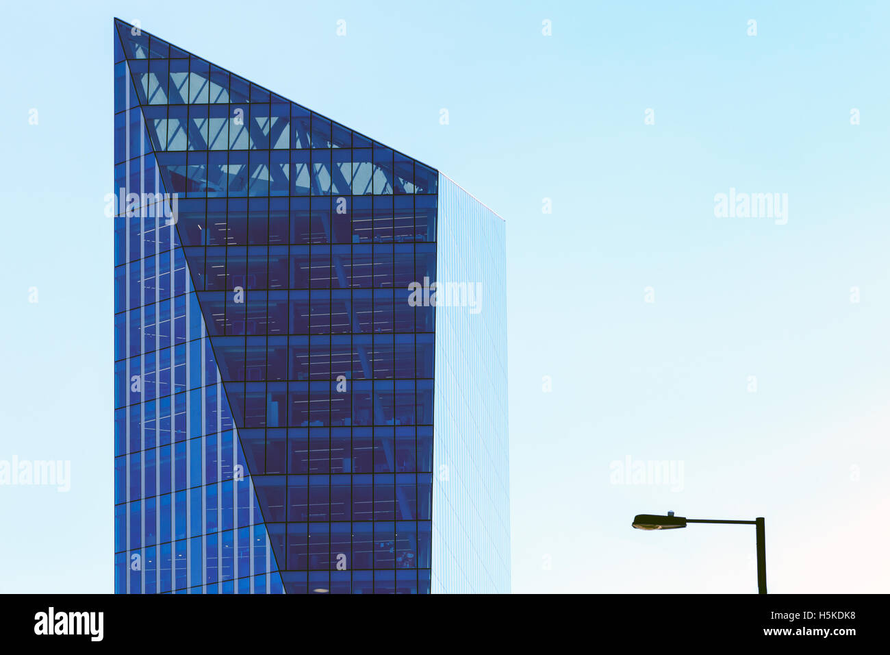 Modern office building (UBM headquarter) and a lamppost against a blue ...