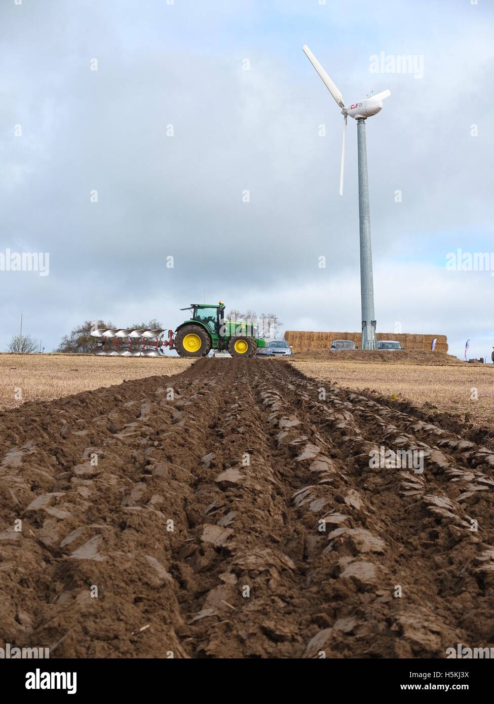 Ploughed furrows, a tractor, windmill and hay bale at Highoredish Farm ...