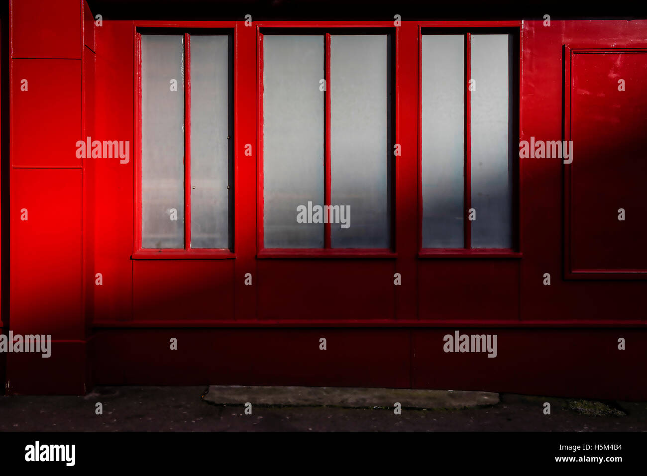 Red building metal windows, half in diagonal shadow Stock Photo - Alamy