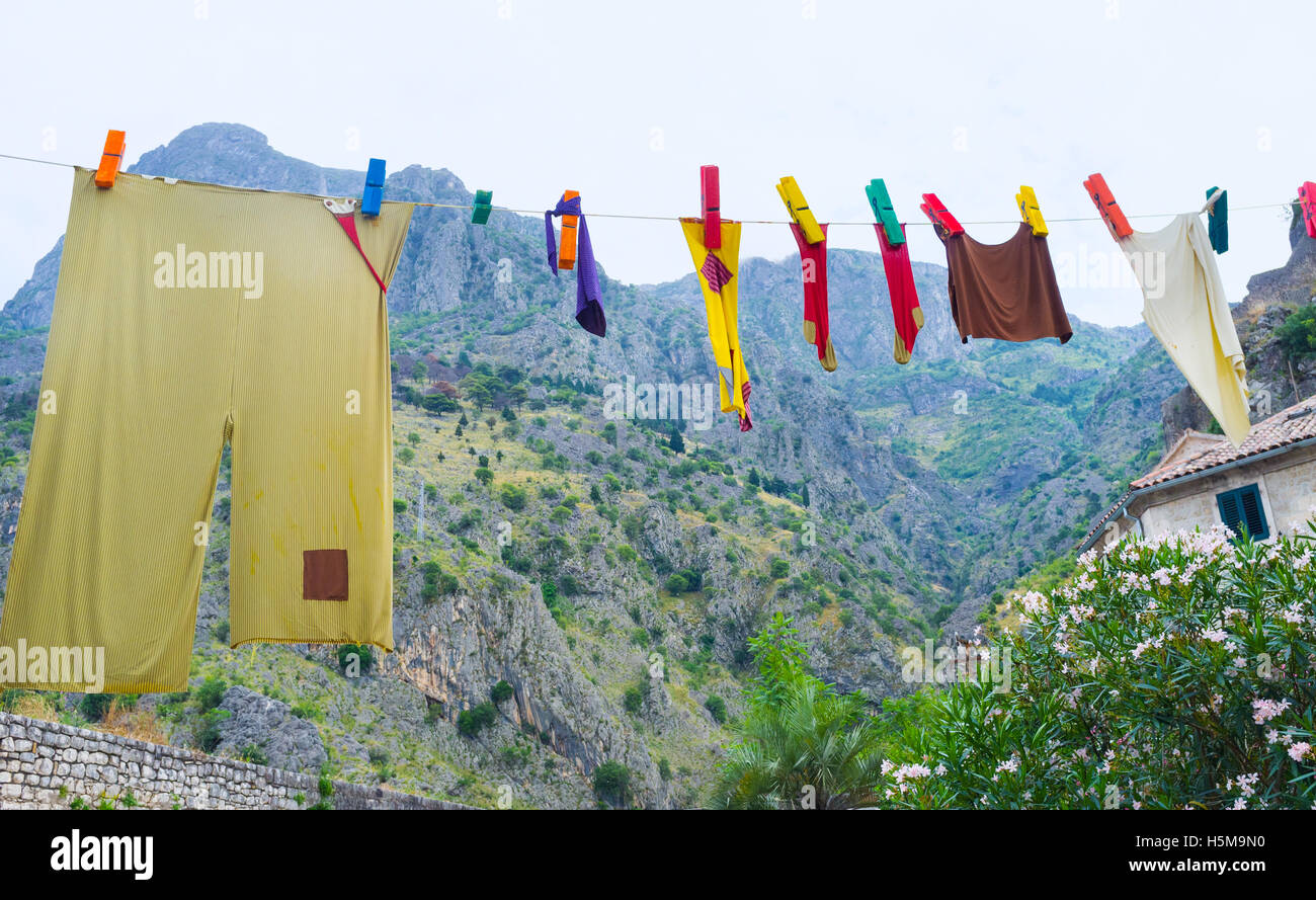 The shorts and socks are drying on big colorful wooden pins on one of ...