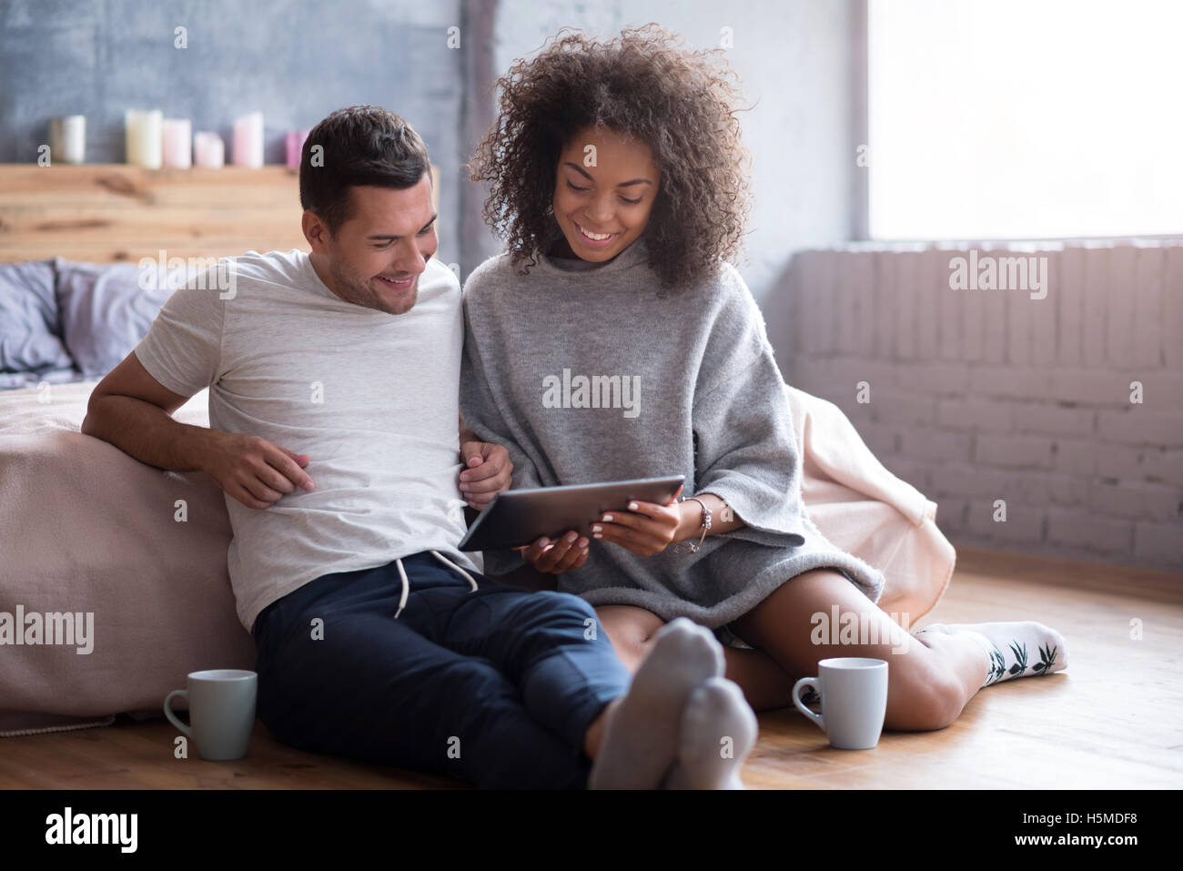 Sweet couple watching film together in a bedroom Stock Photo - Alamy