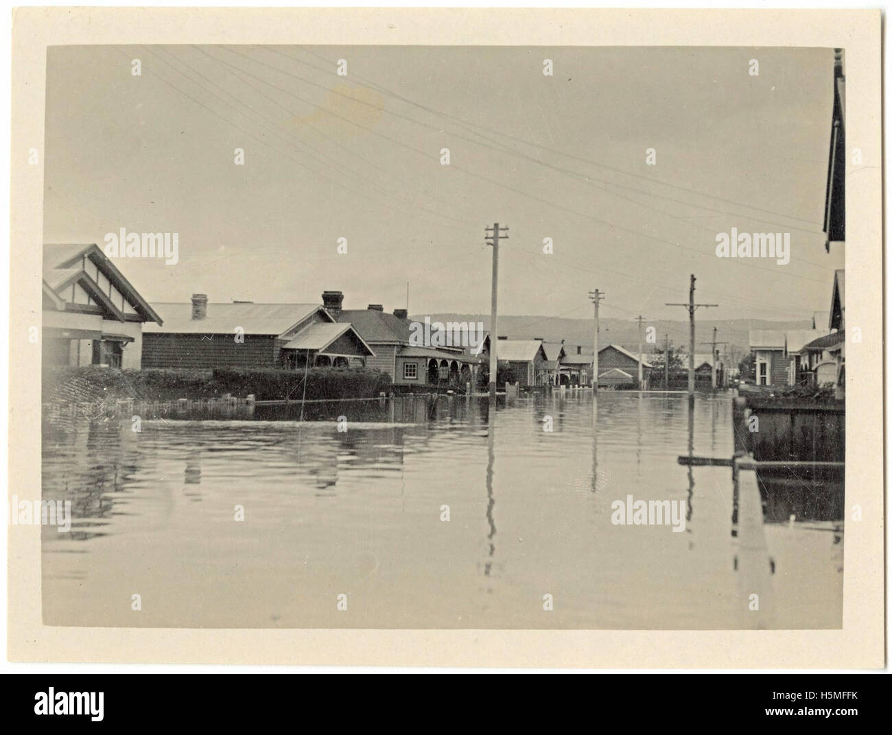 A residential street is shown flooded, likely due to heavy rainfall or ...