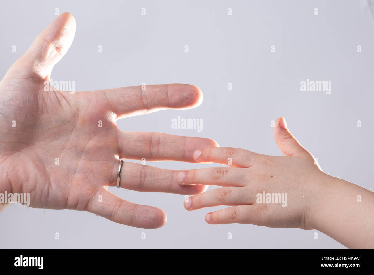 adult and child's hand touching help tenderness Stock Photo - Alamy