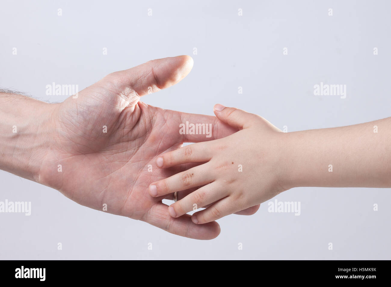 Adult hands hold childs hand hi-res stock photography and images - Alamy