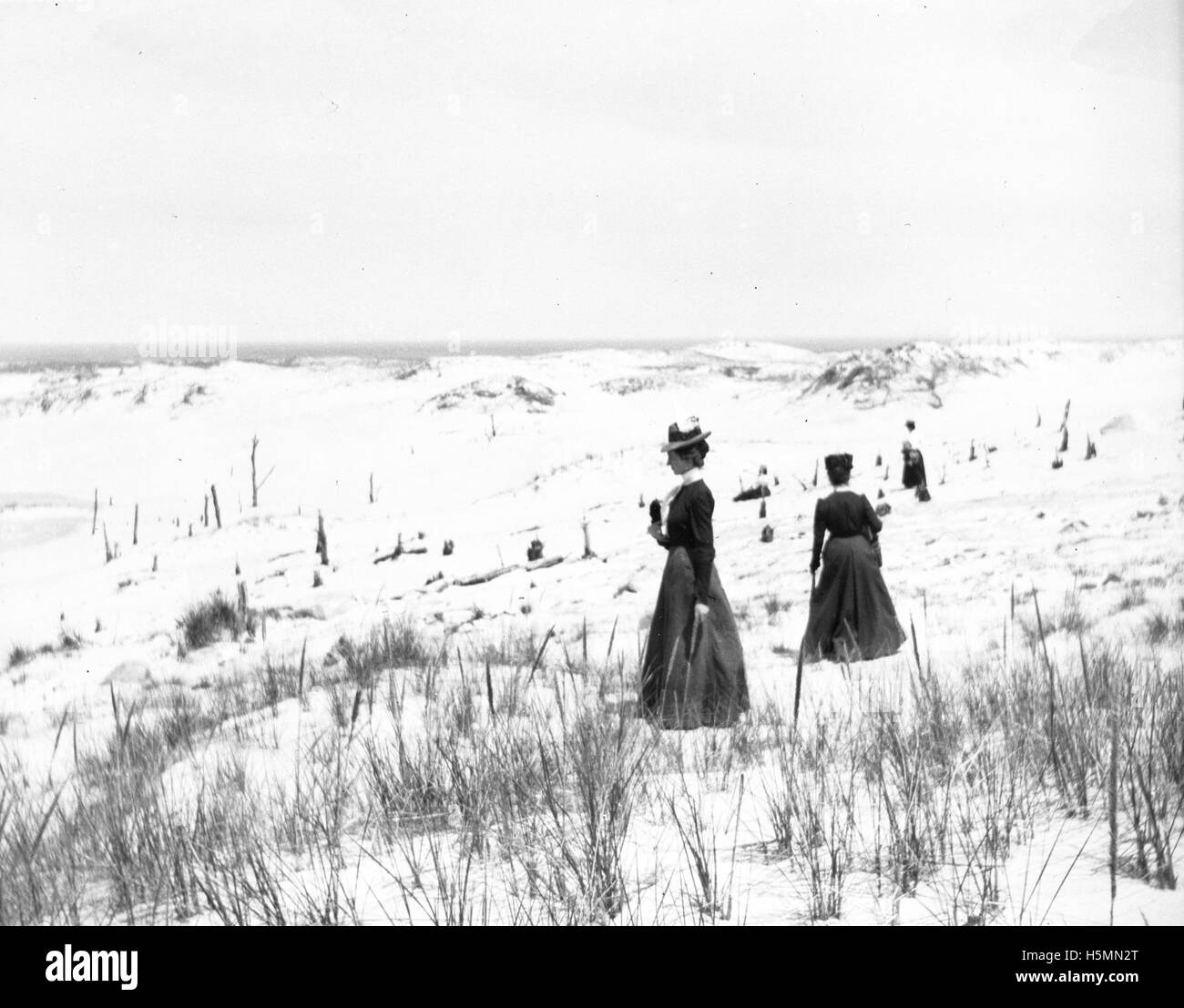 The photograph shows a lighthouse and its keeper at Ipswich Beach ...