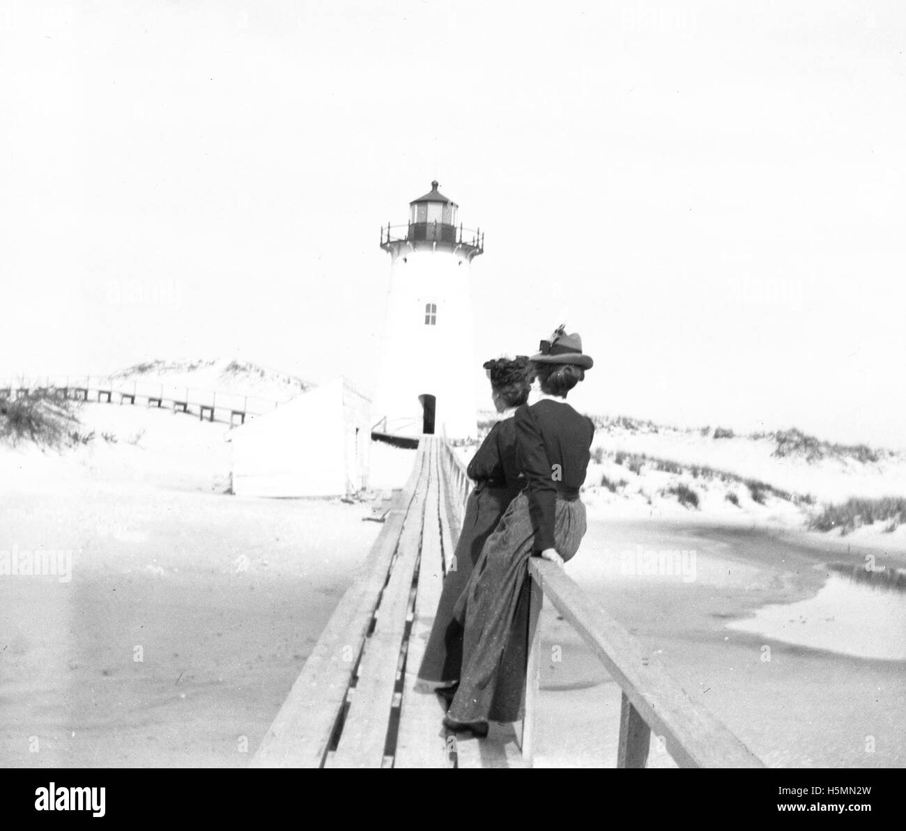 A photograph showing a lighthouse and its keeper at Ipswich Beach on ...