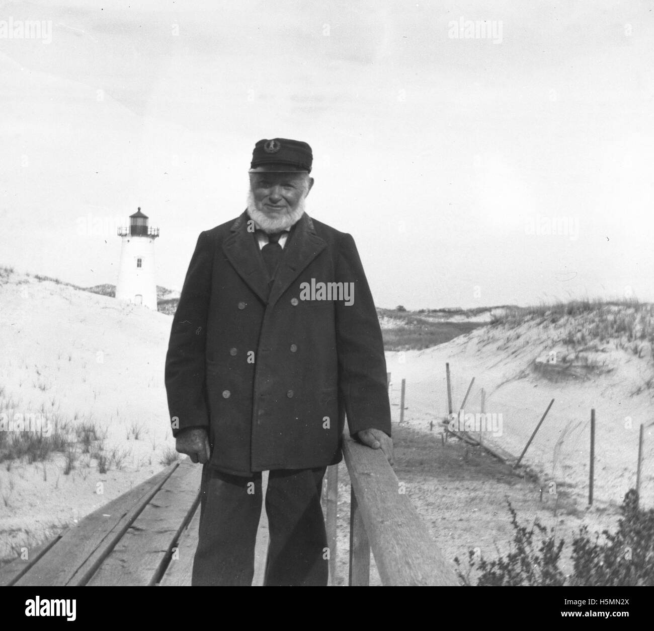 This photograph features a lighthouse and its keeper at Ipswich Beach ...