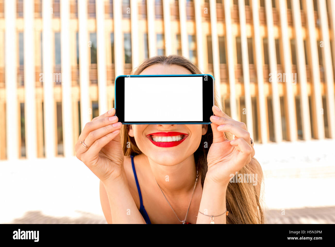 Woman's face with phone outdoors Stock Photo - Alamy