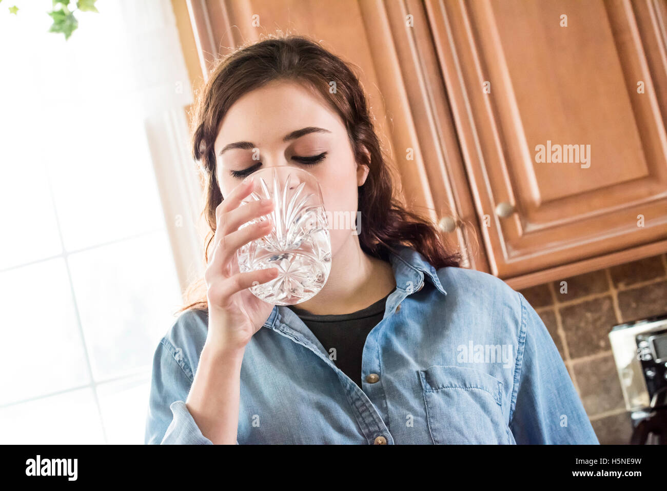 Young adult drinking water Stock Photo - Alamy