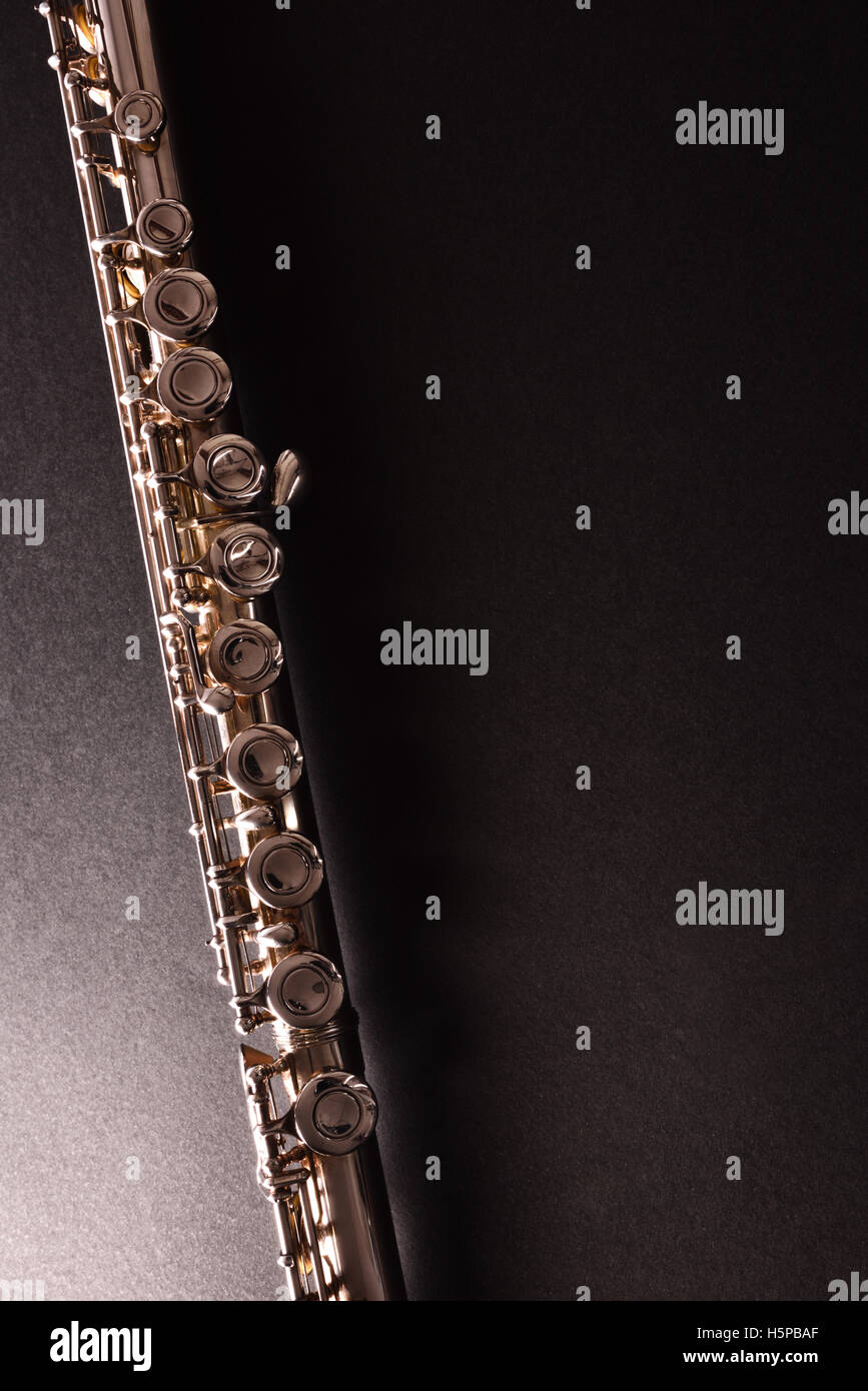 Detail of transverse flute on black table. Vertical composition. Top ...