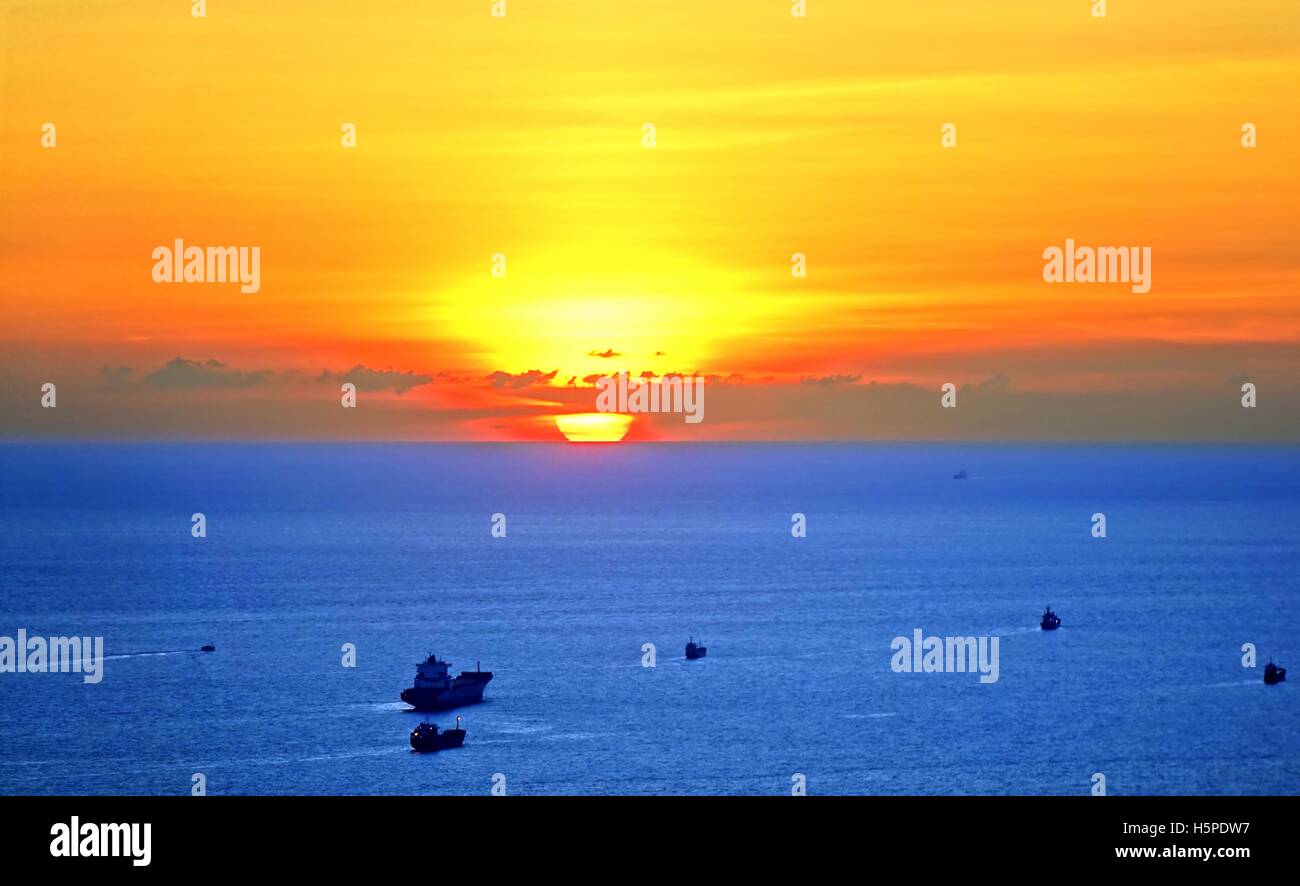 Beautiful sunset in the ocean with ships in the foreground Stock Photo ...