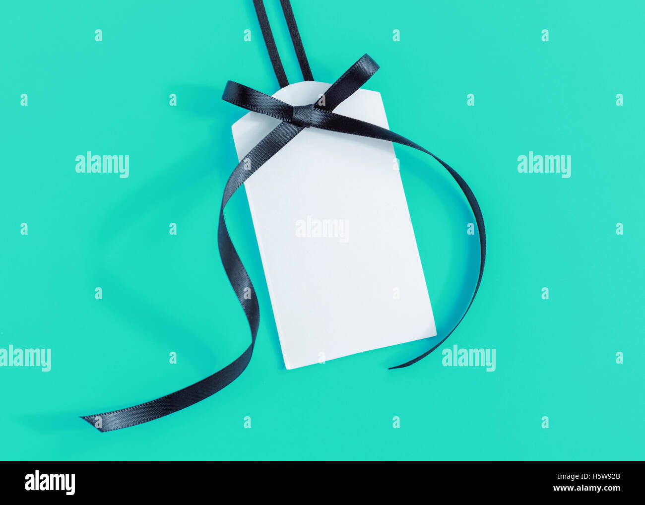 Gift tag with ribbon on cyan blue background Stock Photo - Alamy