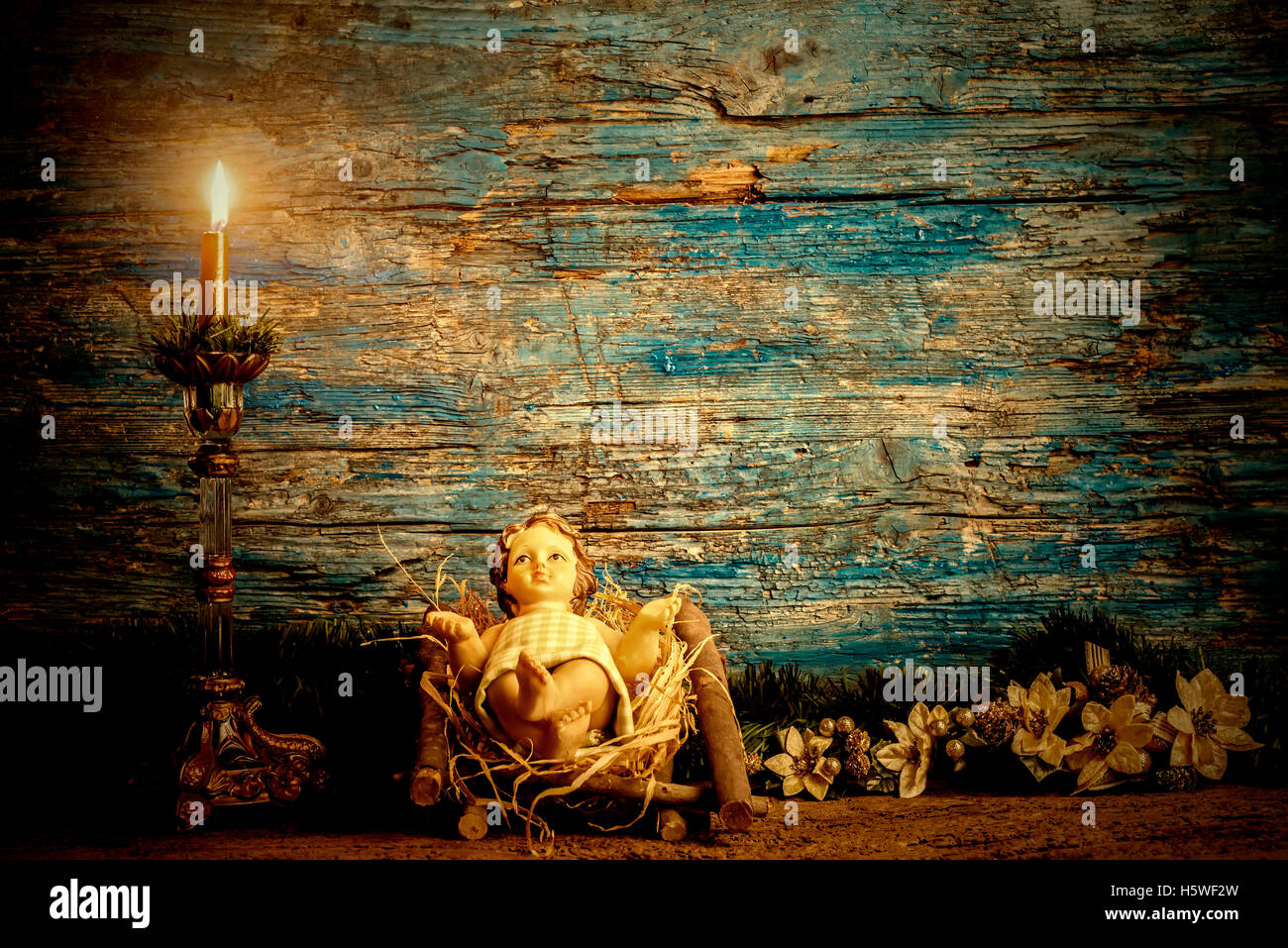 Christmas card, baby Jesus in his crib and vintage candle in rustic ...