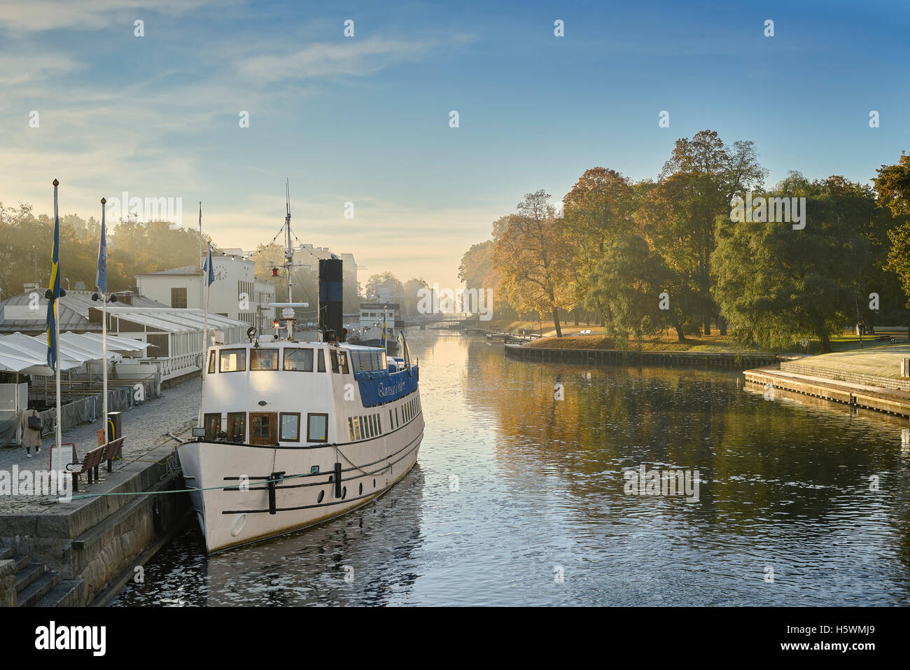 Old steamboat in the Fyris river at a misty autumn morning at Islandsfallet, Uppsala, Sweden ...