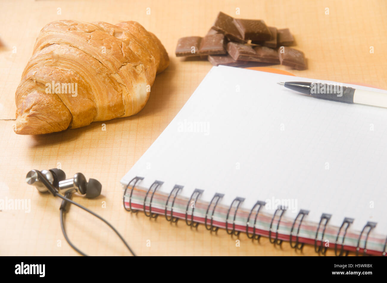 Croissant with chocolate, notebook and headphones Stock Photo - Alamy