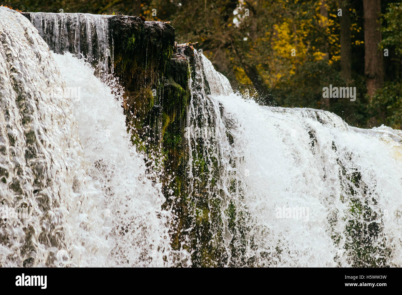 Waterfall edge closeup against autumnal forest. Falling water, from ...
