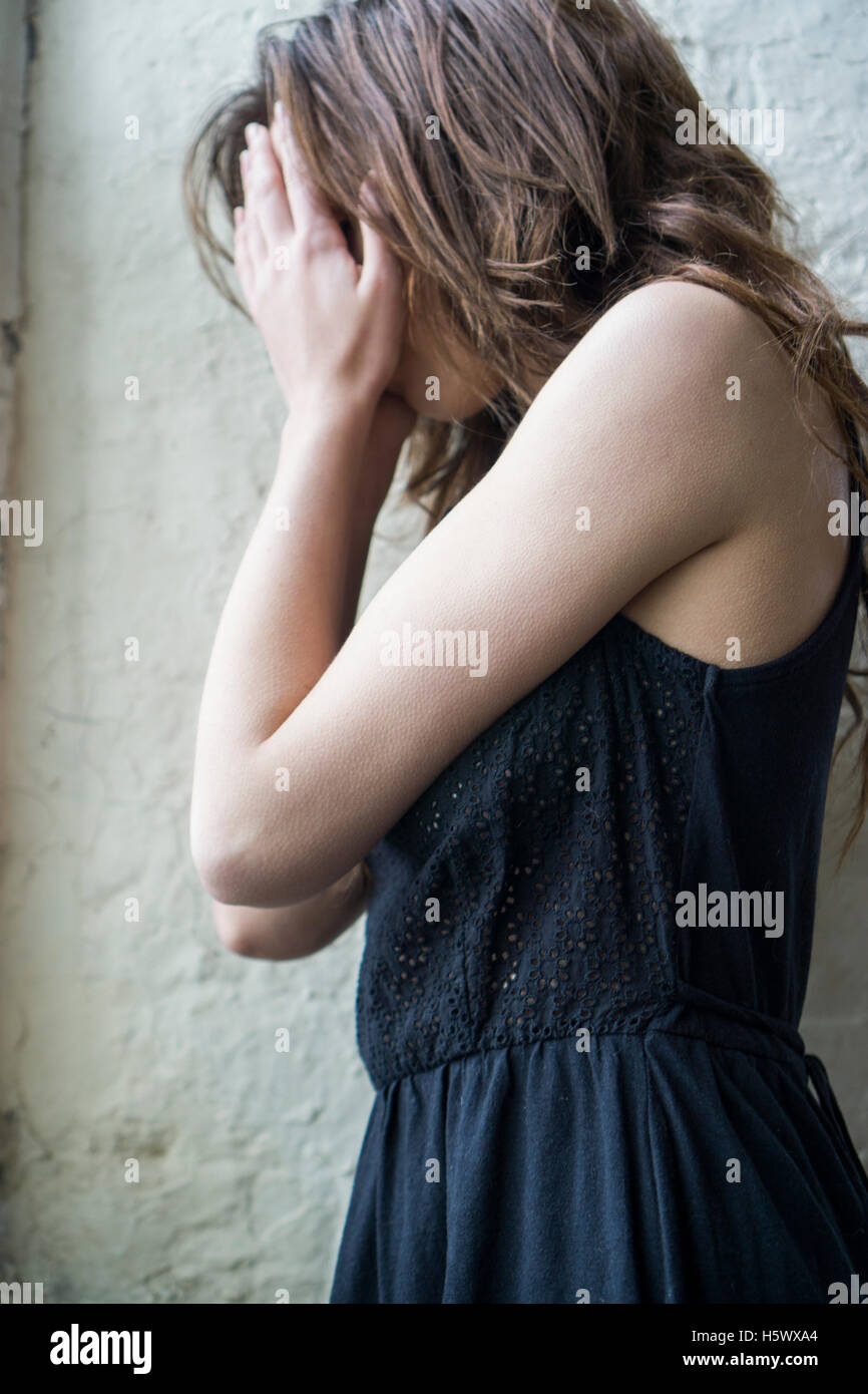 Young woman hiding face with hands Stock Photo - Alamy