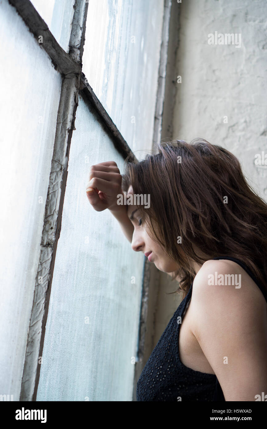 Sad woman leaning on the window Stock Photo - Alamy