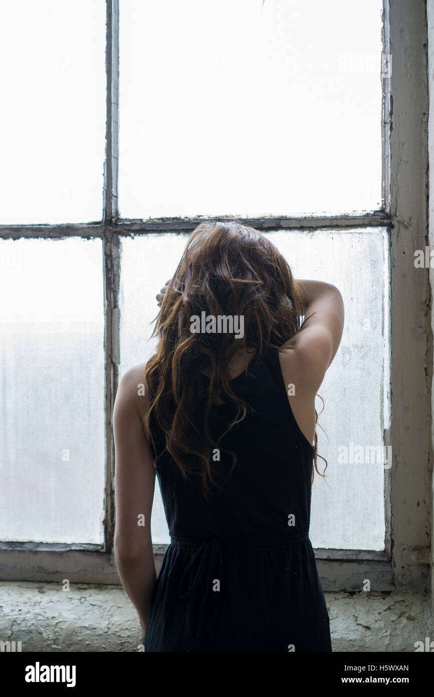 Sad woman leaning on the window Stock Photo - Alamy