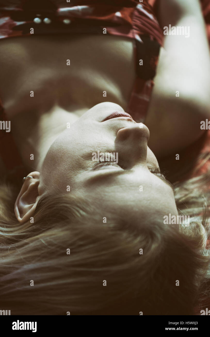 Sad woman laying down in bed Stock Photo - Alamy