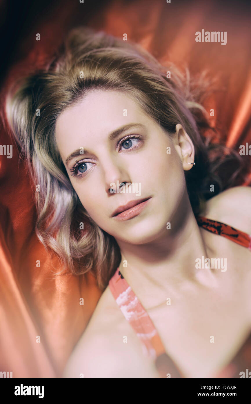 Sad woman laying down in bed Stock Photo - Alamy