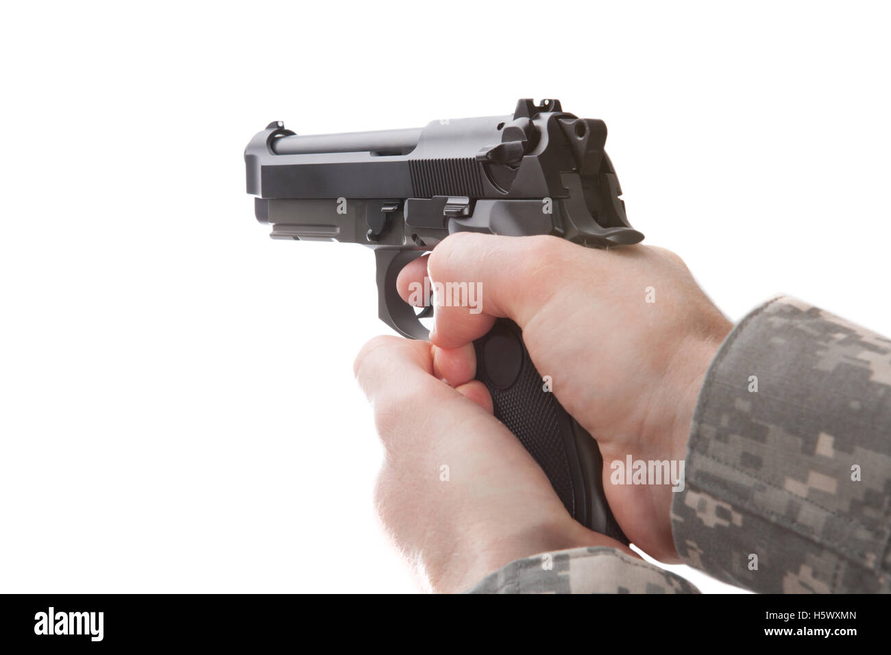 Man in military uniform holding hand gun and ready to use it Stock ...