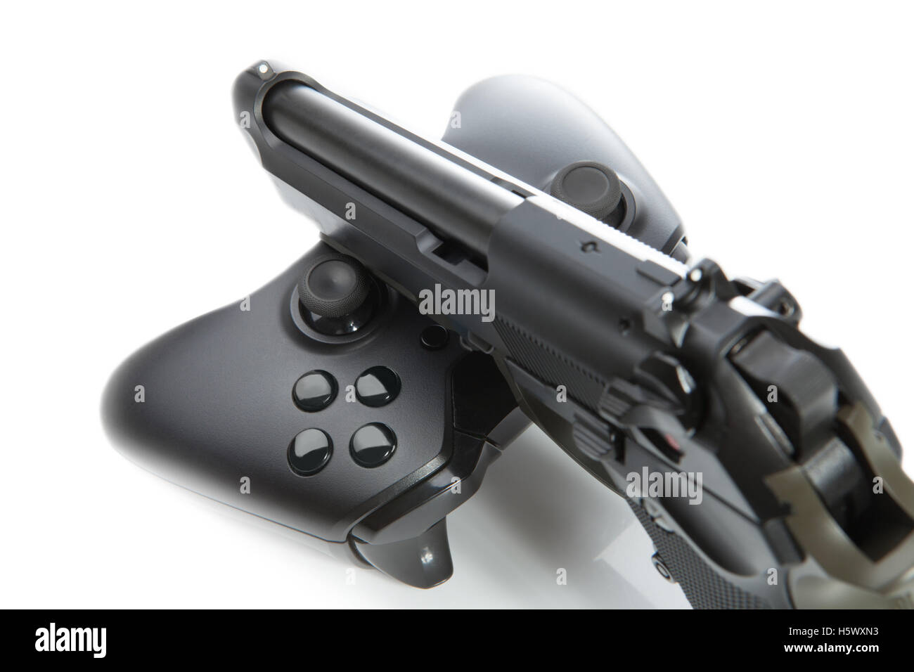 Game controller and a real handgun - close up studio shot. Virtual and ...