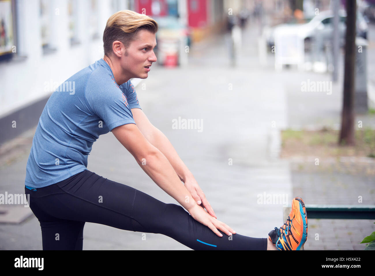young handsome man stretching outdoors on the pavement Stock Photo - Alamy