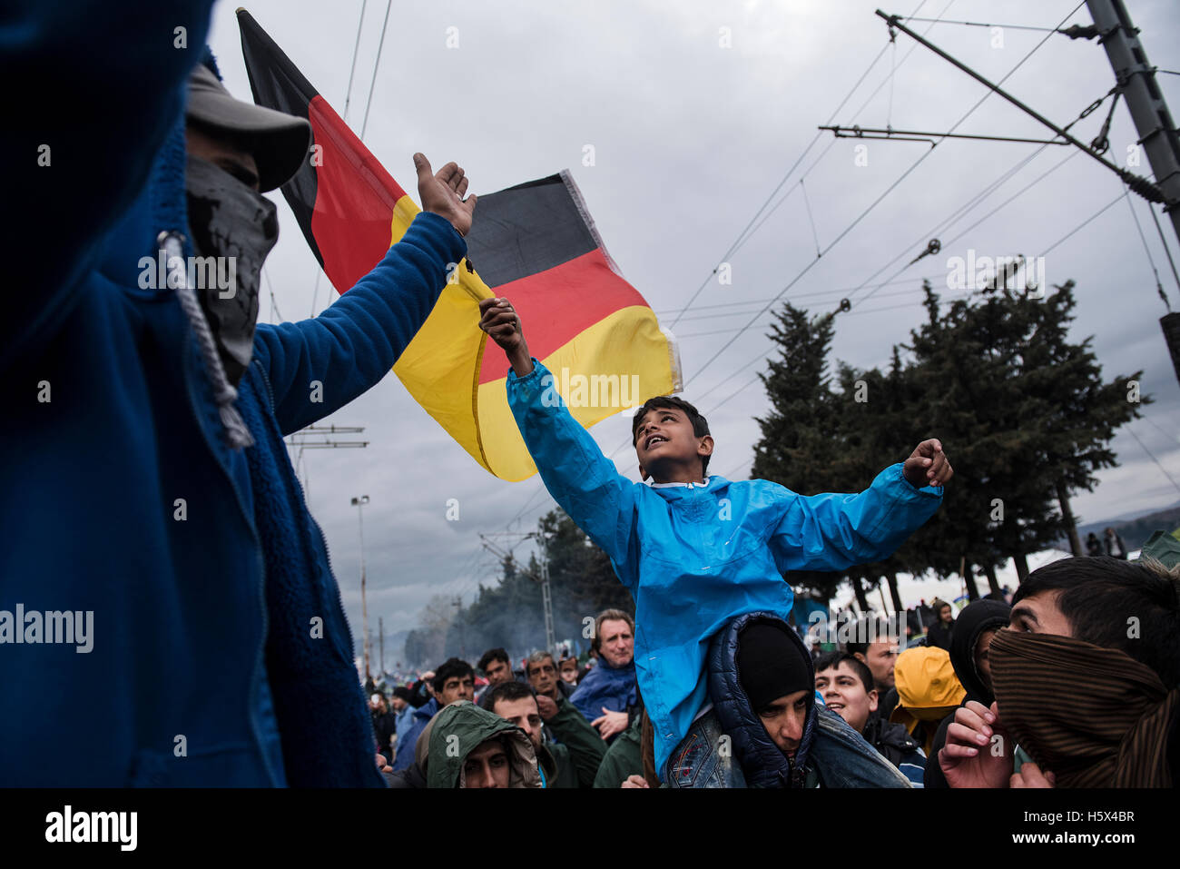 A Refugee boy holds a German flag, as refugees and migrants demonstrate ...